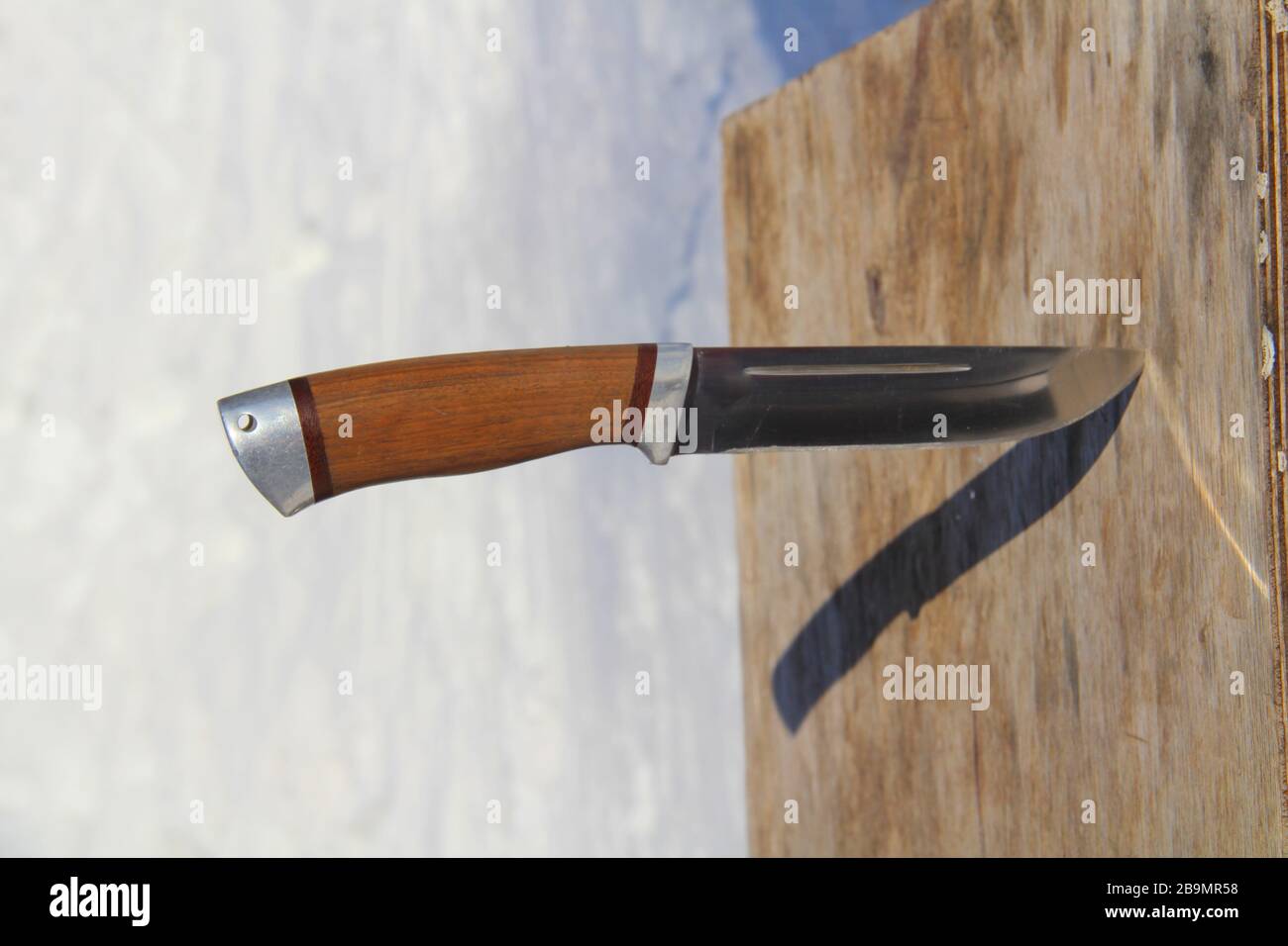 Knife stuck in a wooden table on a white snow background. Stock photo ...