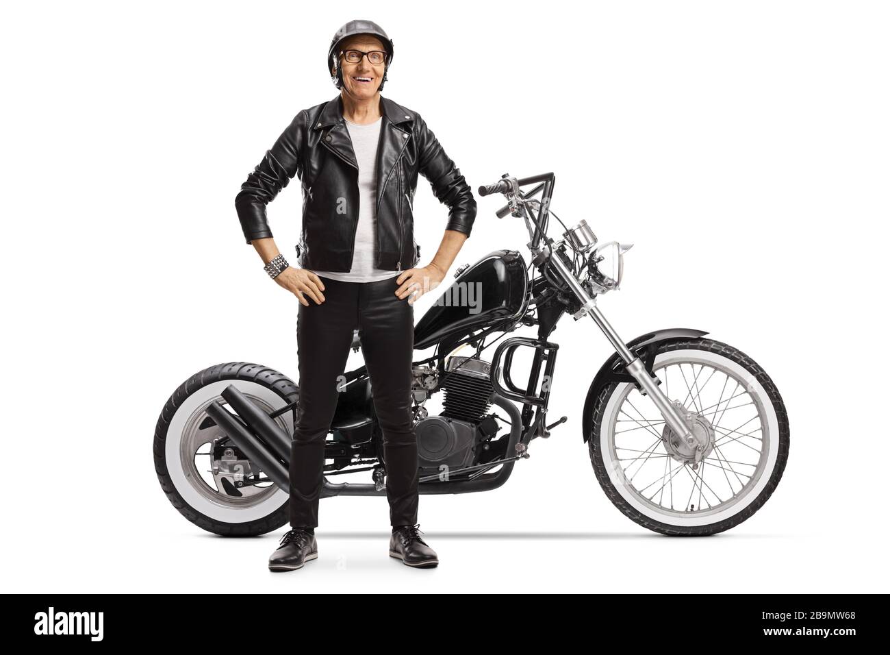 Full length portrait of an elderly male biker standing next to a custom ...