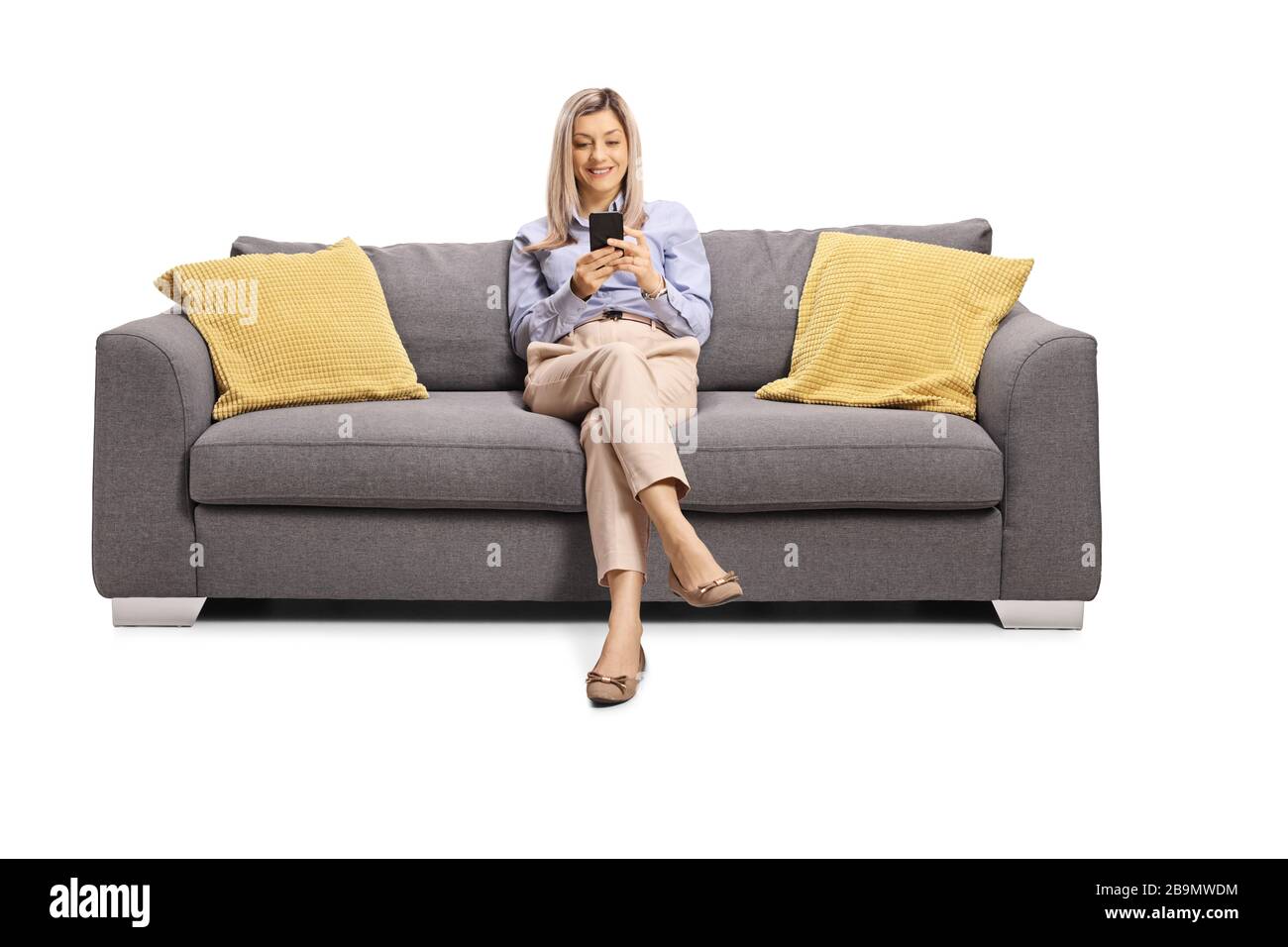 Woman resting on a sofa and holding a mobile phone isolated on white ...