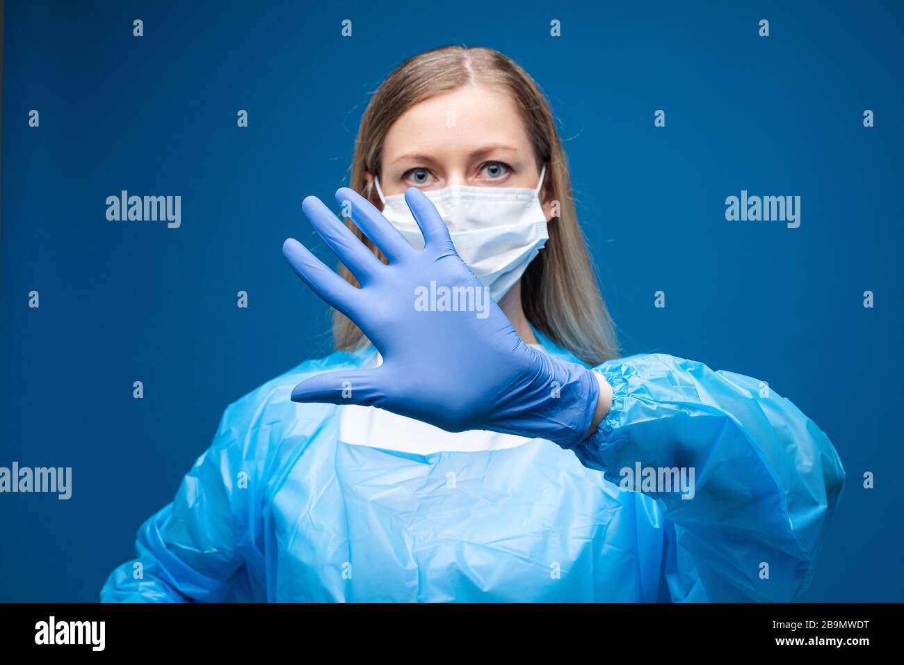 Doctor in medical gown showing stop hand gesture Stock Photo - Alamy