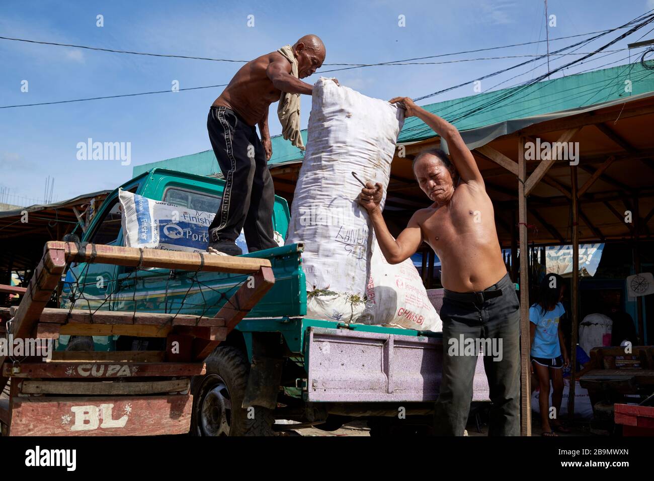 Porter carrying a heavy load in the streets of the Carbon public market ...