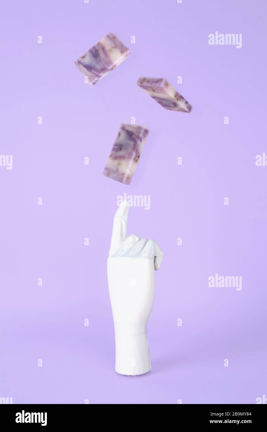 Gloved hand playing with levitating soap bars. Cleaning Hands Concept ...