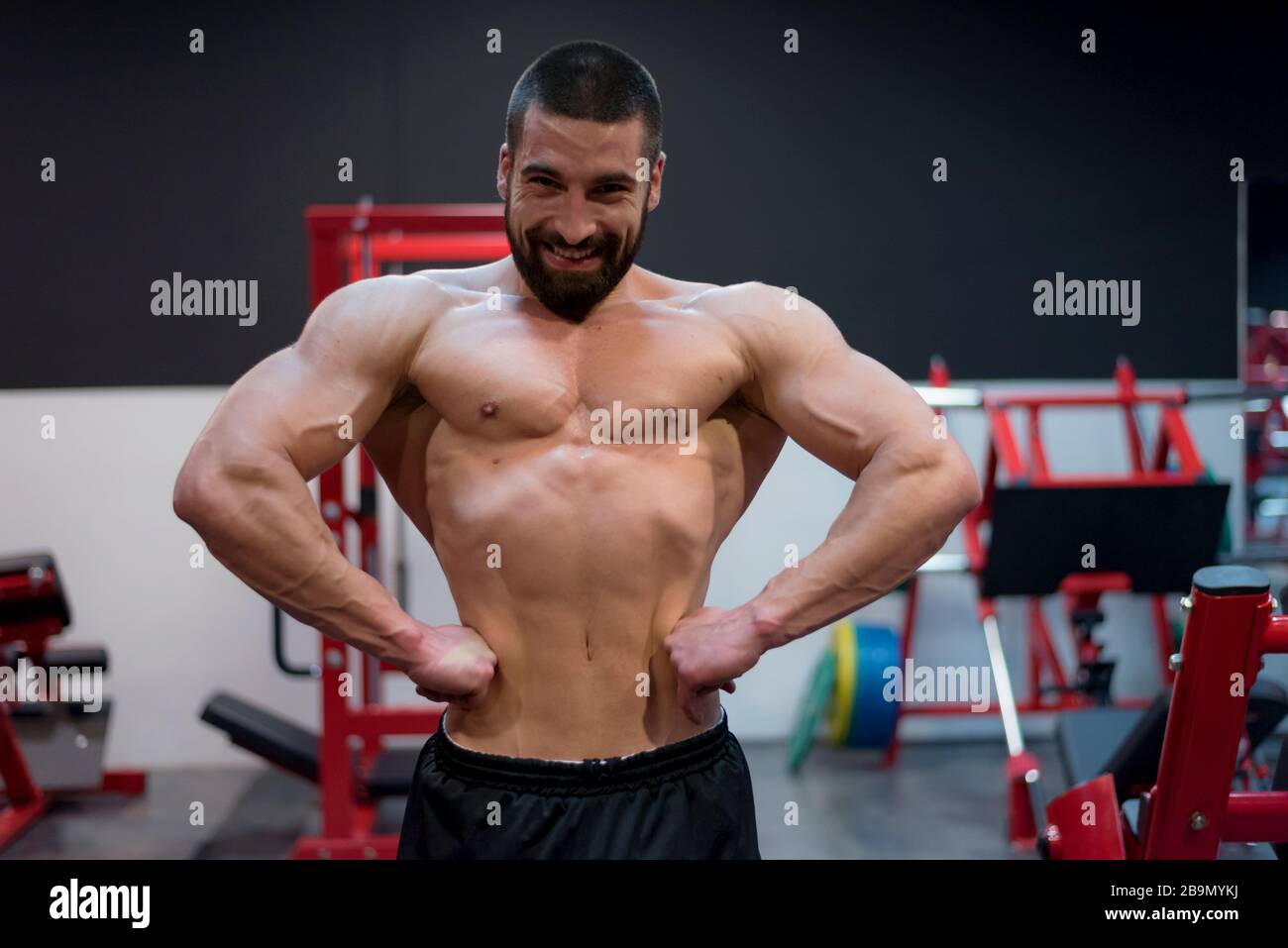 Fitness model Man posing in the gym. Handsome man with big muscles ...