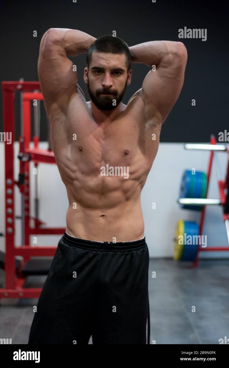 Fitness model Man posing in the gym. Handsome man with big muscles ...