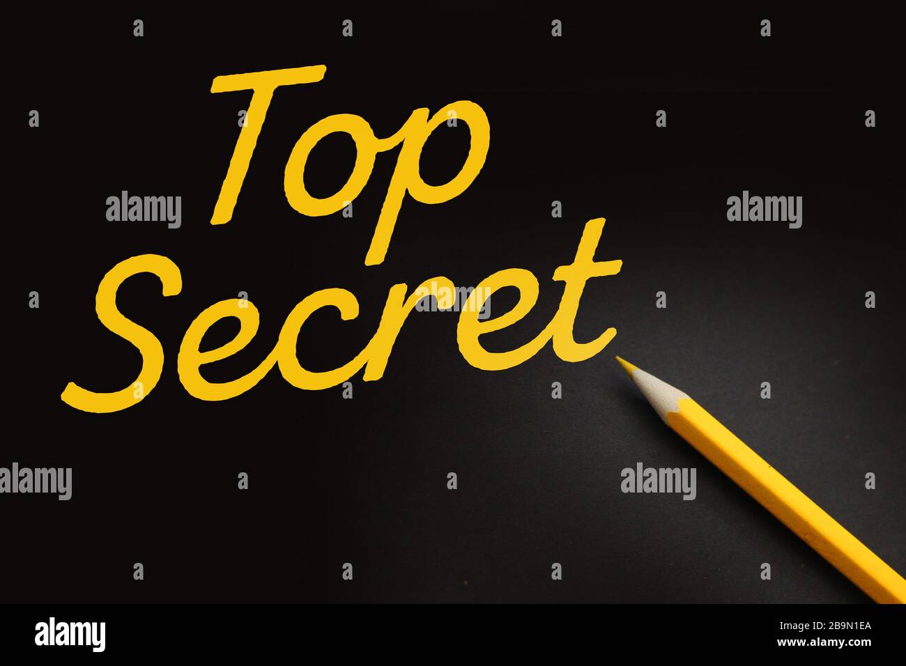 Top secret words written with yellow pen on black background. Business ...