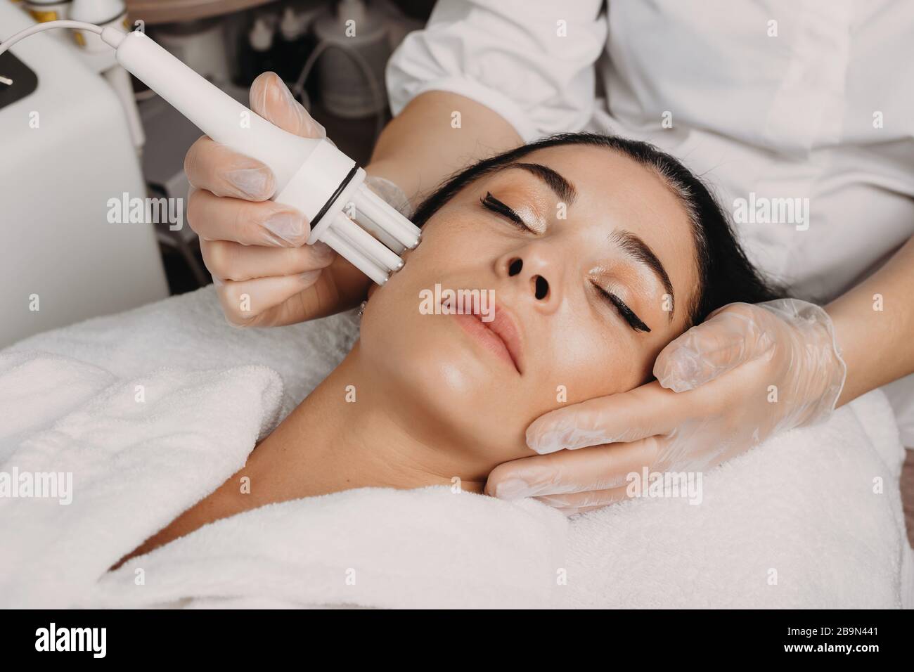 Facial anti aging procedure done at the salon on the face of a brunette ...