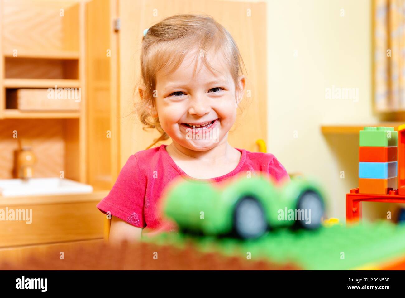 Little girl playing with a toy car Stock Photo - Alamy