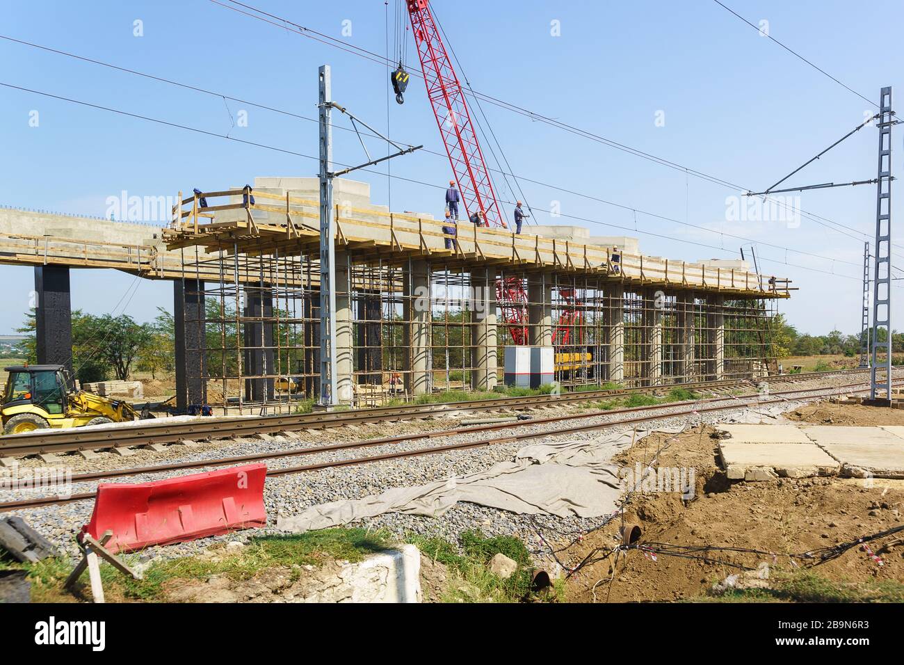 Workers at the construction of an elevated bridge crossing the railway ...