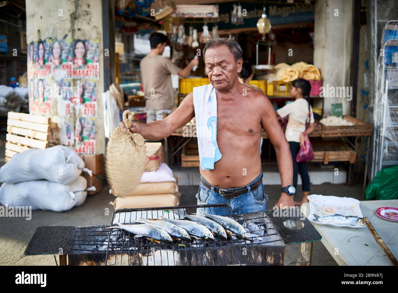 Man cooking fish in a barbecue in the streets of the Carbon public ...