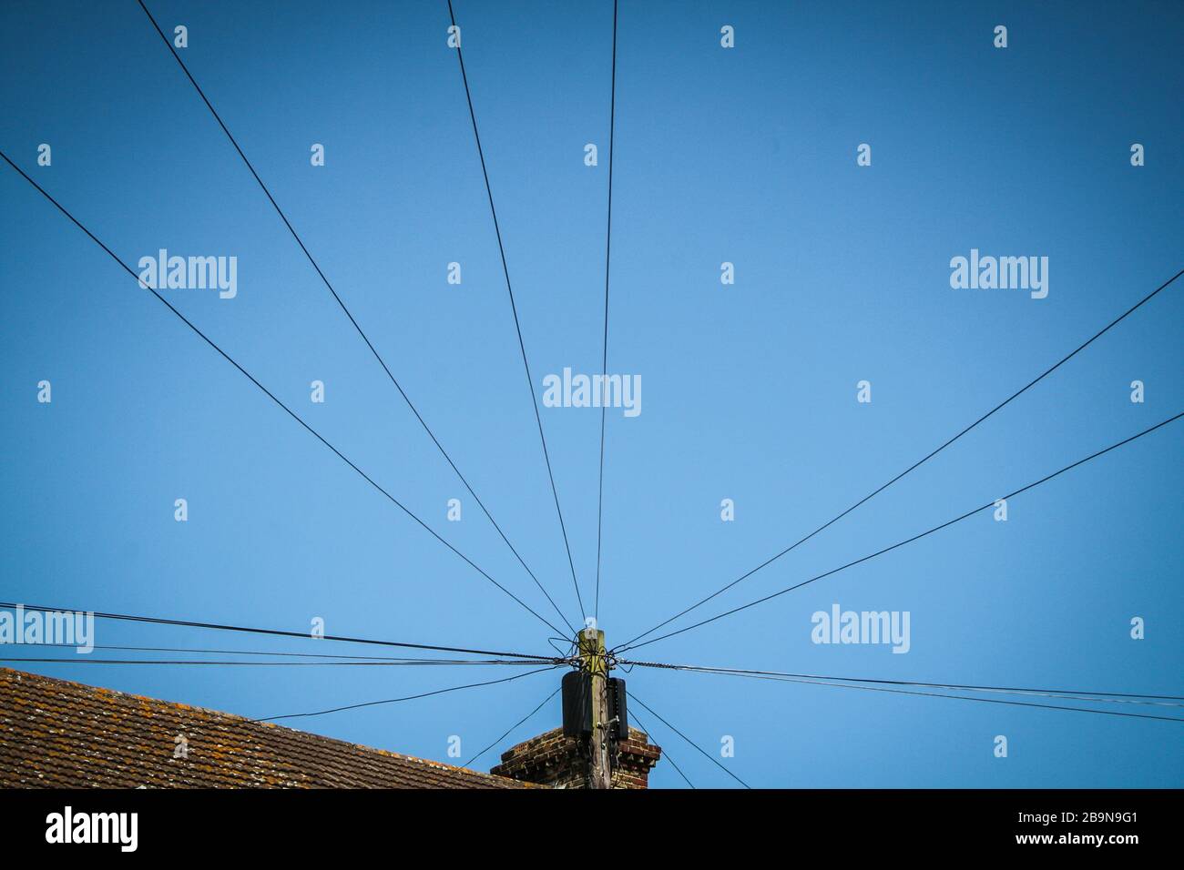 Electric cables connected to a roof like a spider web Stock Photo - Alamy