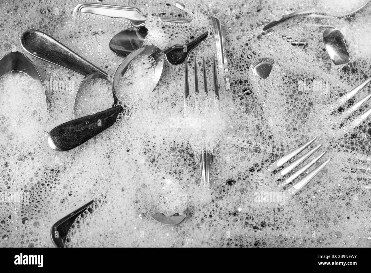 Washing silverware in the sink with soap suds. Cleaning concept Stock ...