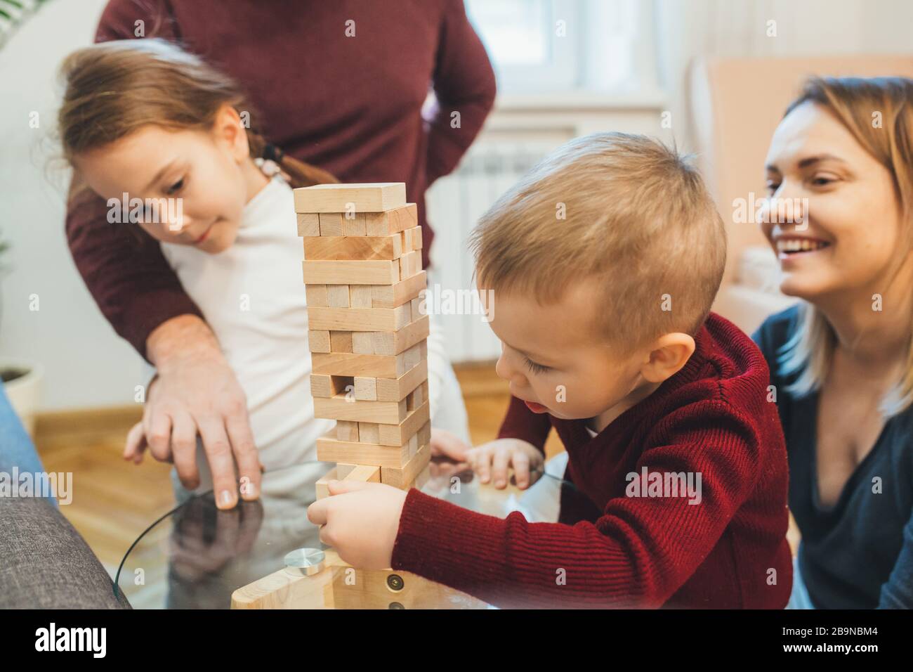 Caucasian family playing jenga with their kids while spending time ...