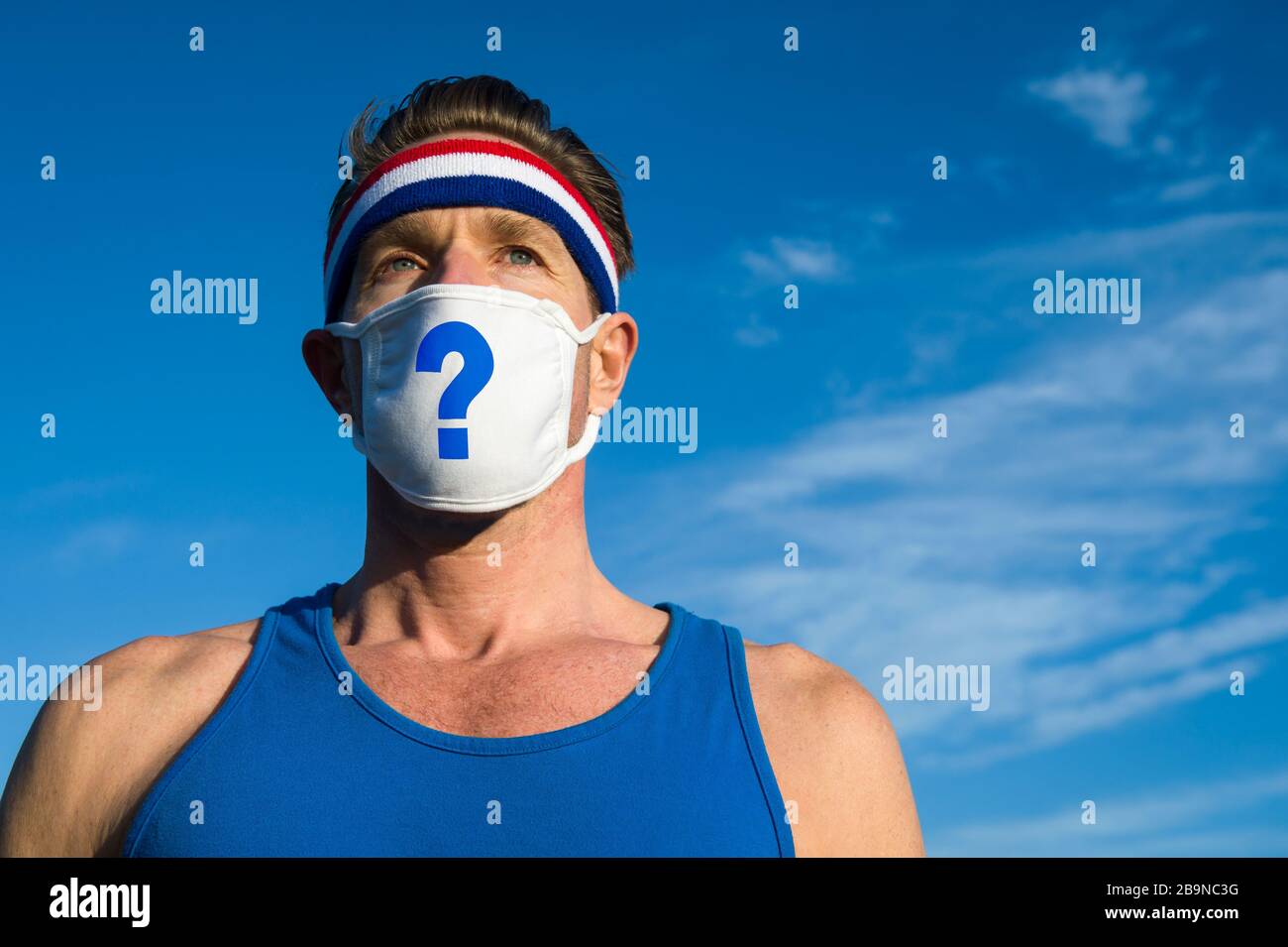 Athlete wearing surgical face mask with question mark standing outdoors ...