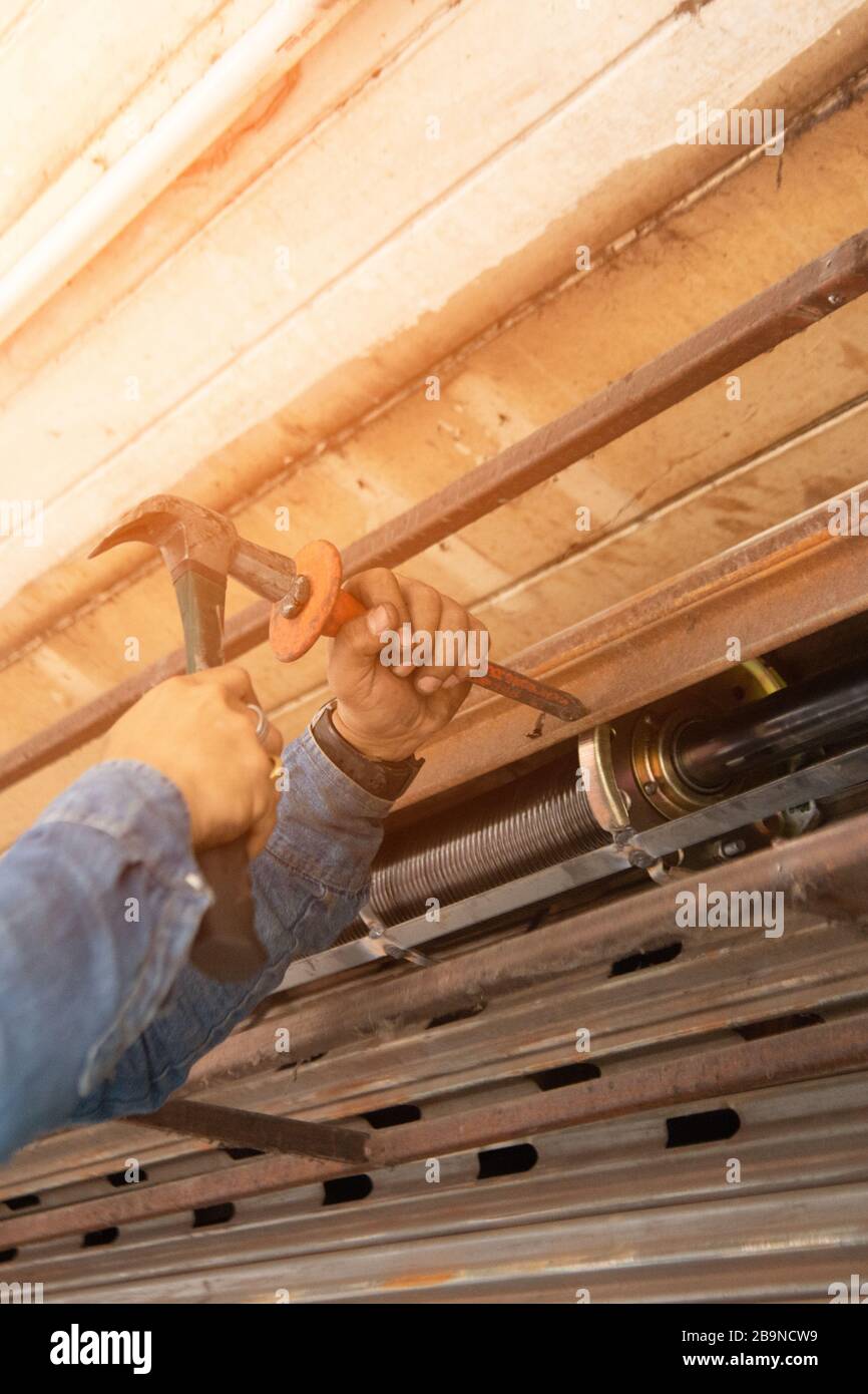 Human hand making holes using hole rolling gate puncher by hammer Stock ...