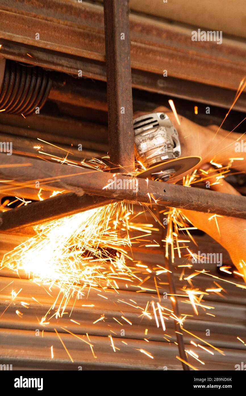 The worker is sawing and cutting metal part of steel in a shop Stock ...