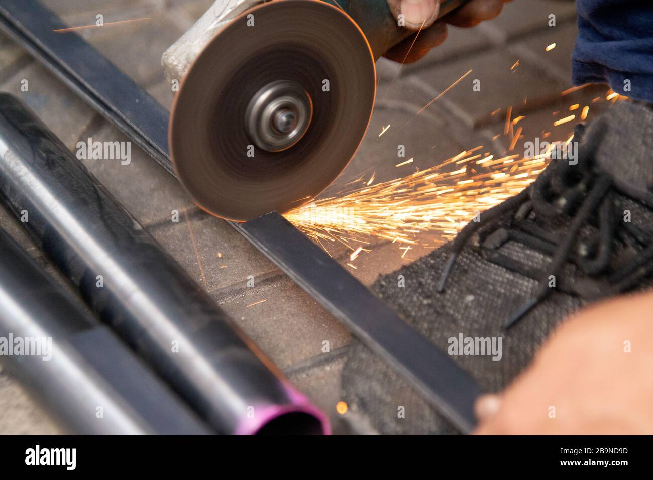 The worker is sawing and cutting metal part of steel in a shop Stock ...