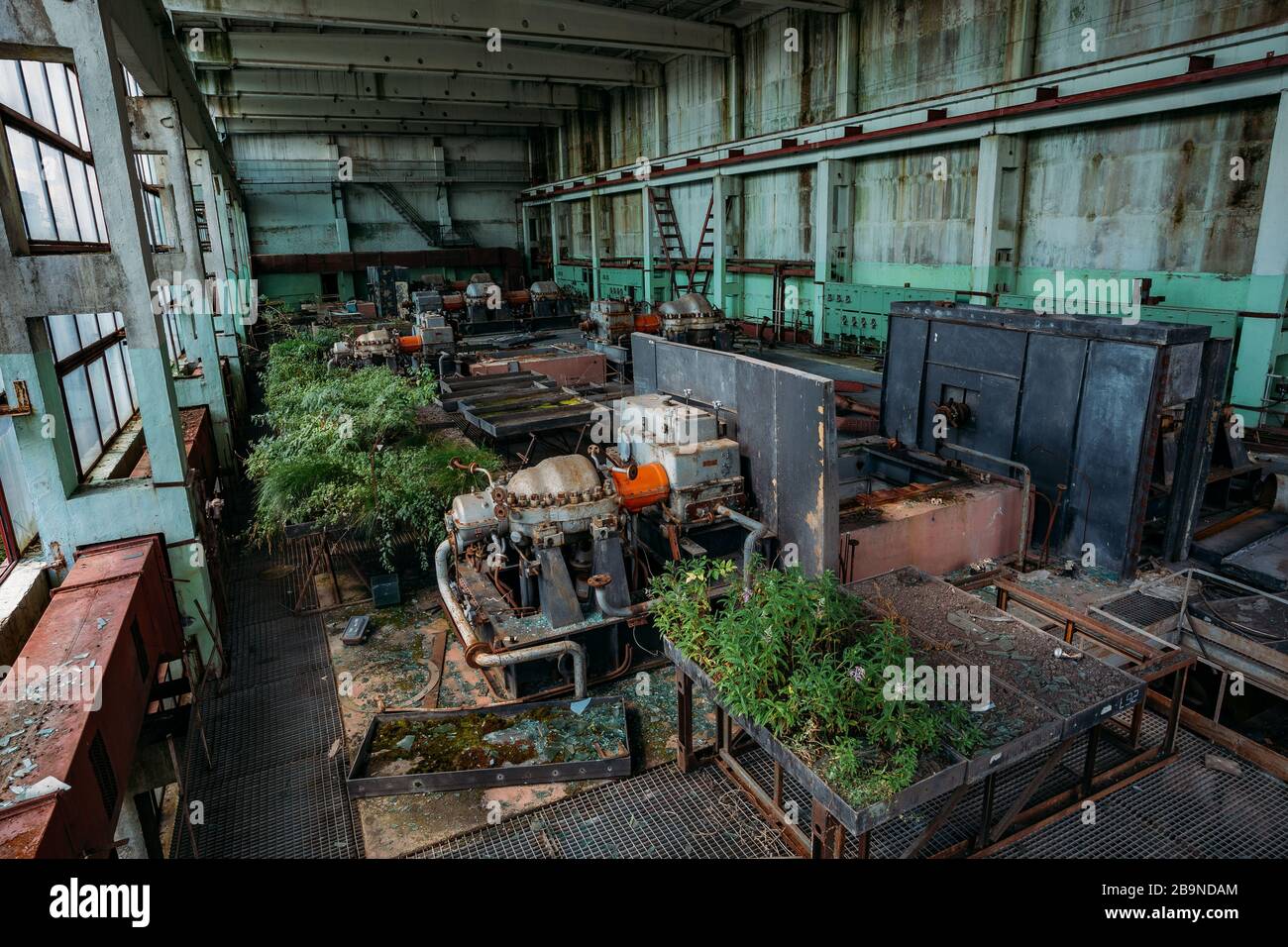 Old abandoned overgrown factory with rusty remains of industrial ...