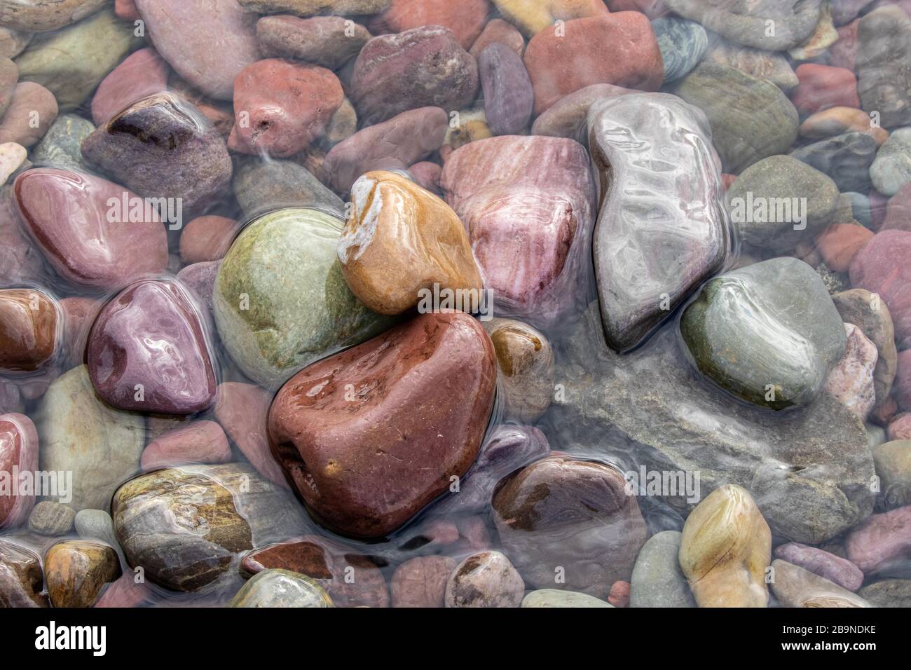 Colorful polished stones in the water Stock Photo - Alamy