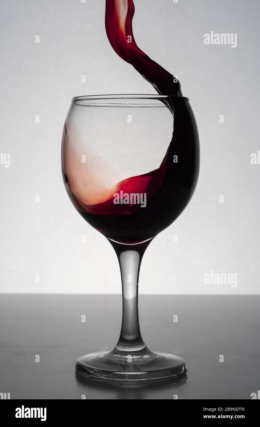 red wine splashing out of a glass, isolated on white Stock Photo - Alamy