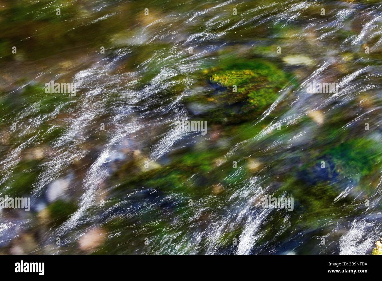 Detail view of flowing water, sun reflexes showing the direction of the ...