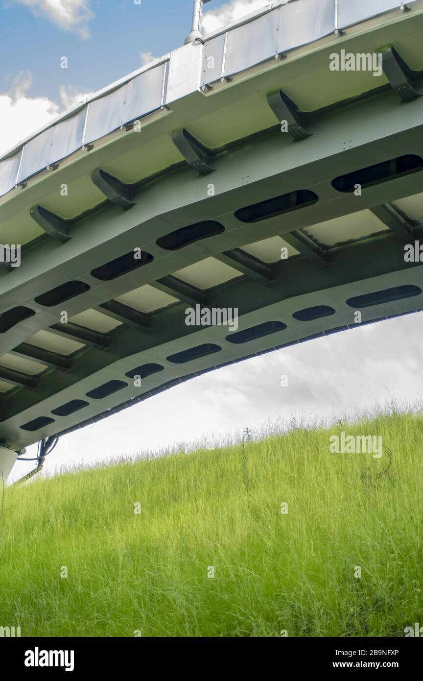 Arched bridge over palm lined road with pedestrian walking on clear ...
