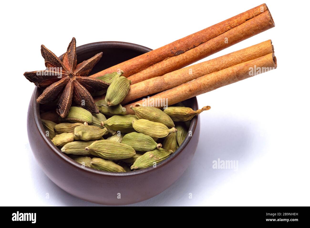Cinnamon, cardamom and anise in a cup on white background Stock Photo ...