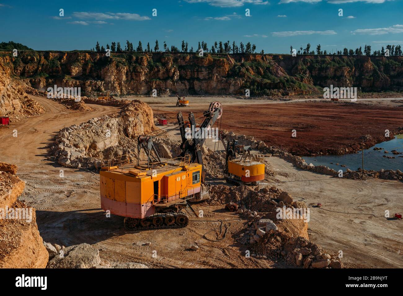 Excavarors working on limestone mining in the flooded quarry Stock ...