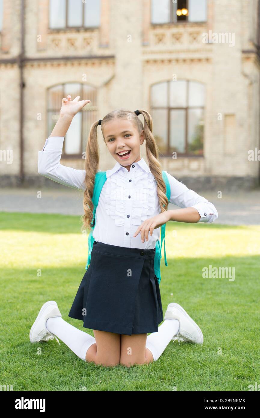 Carefree student. Smiling pupil sit on grass. Have fun. Happy kid ...