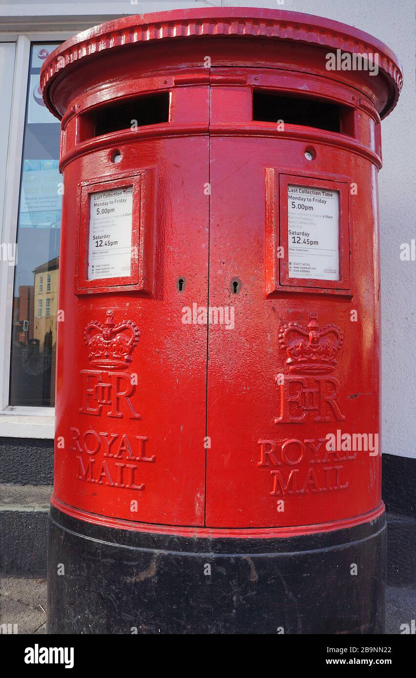 Old Royal mail postbox outside a post office still open amid the coronavirus outbreak Stock ...