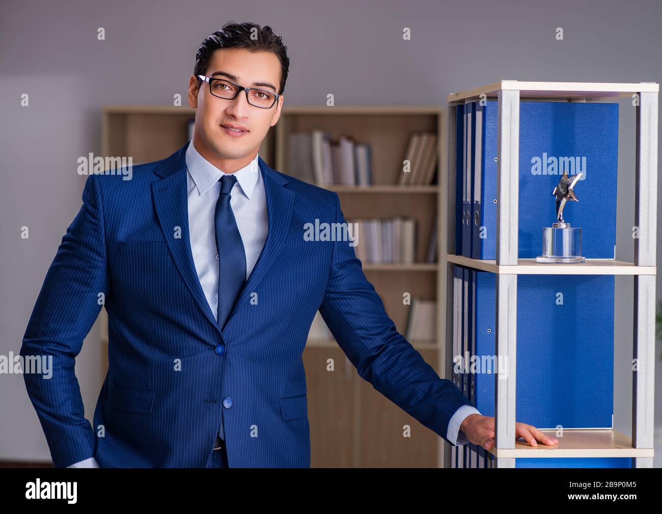 The young man standing next to the shelf with folders Stock Photo - Alamy