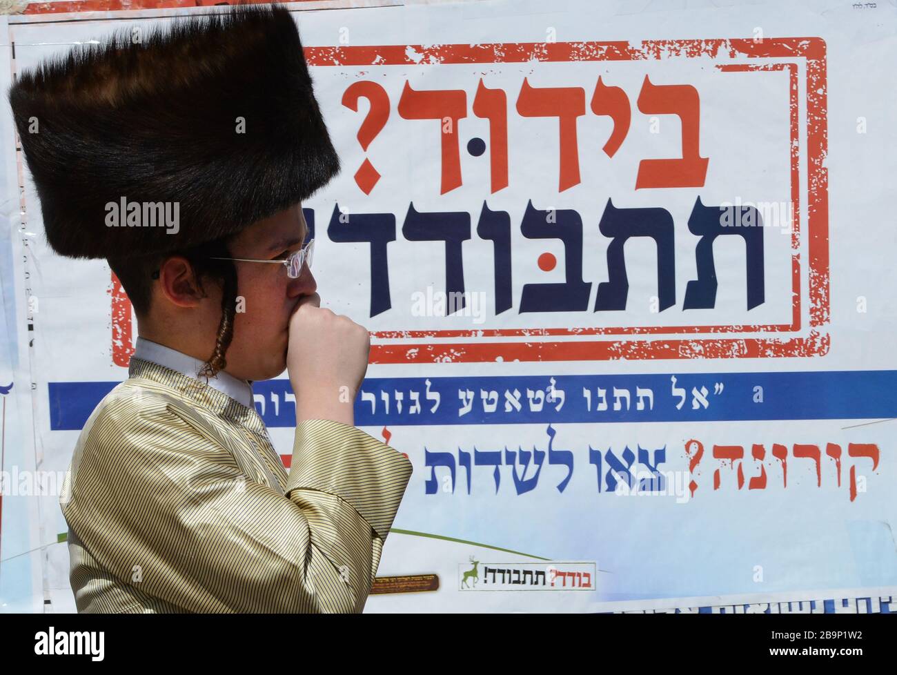 A Hasidic man wearing a Shtreimel ( traditional fur hat ) walking by a ...