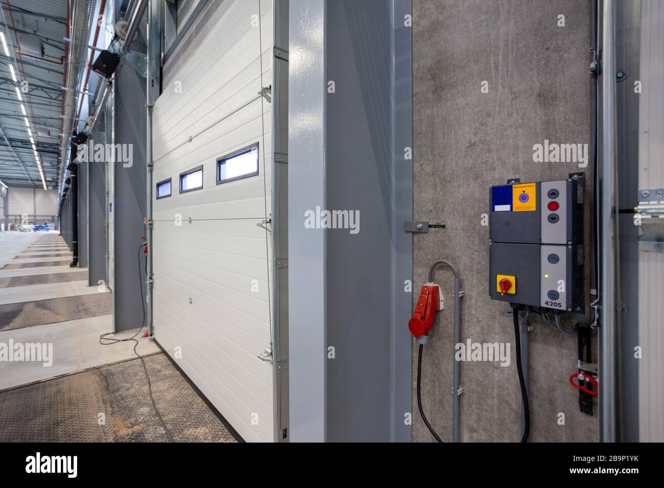 Interior shot of a warehouse with a control panel next to the door ...