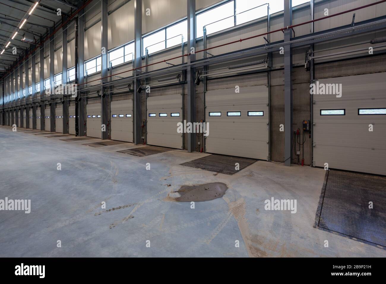 Interior shot of a warehouse with a large row of loading doors Stock ...