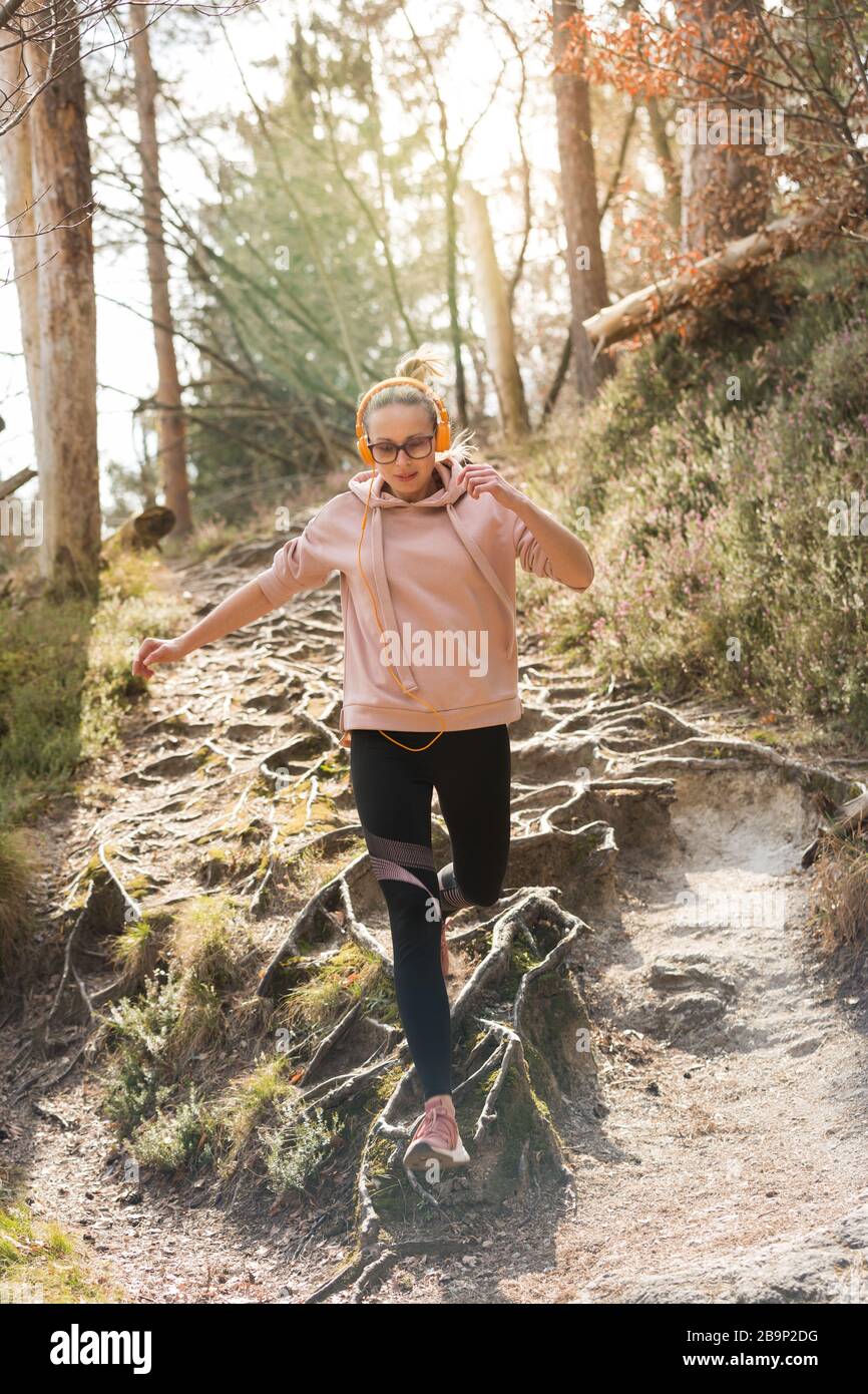 Active sporty woman running in autumn fall forest jumping over the ...