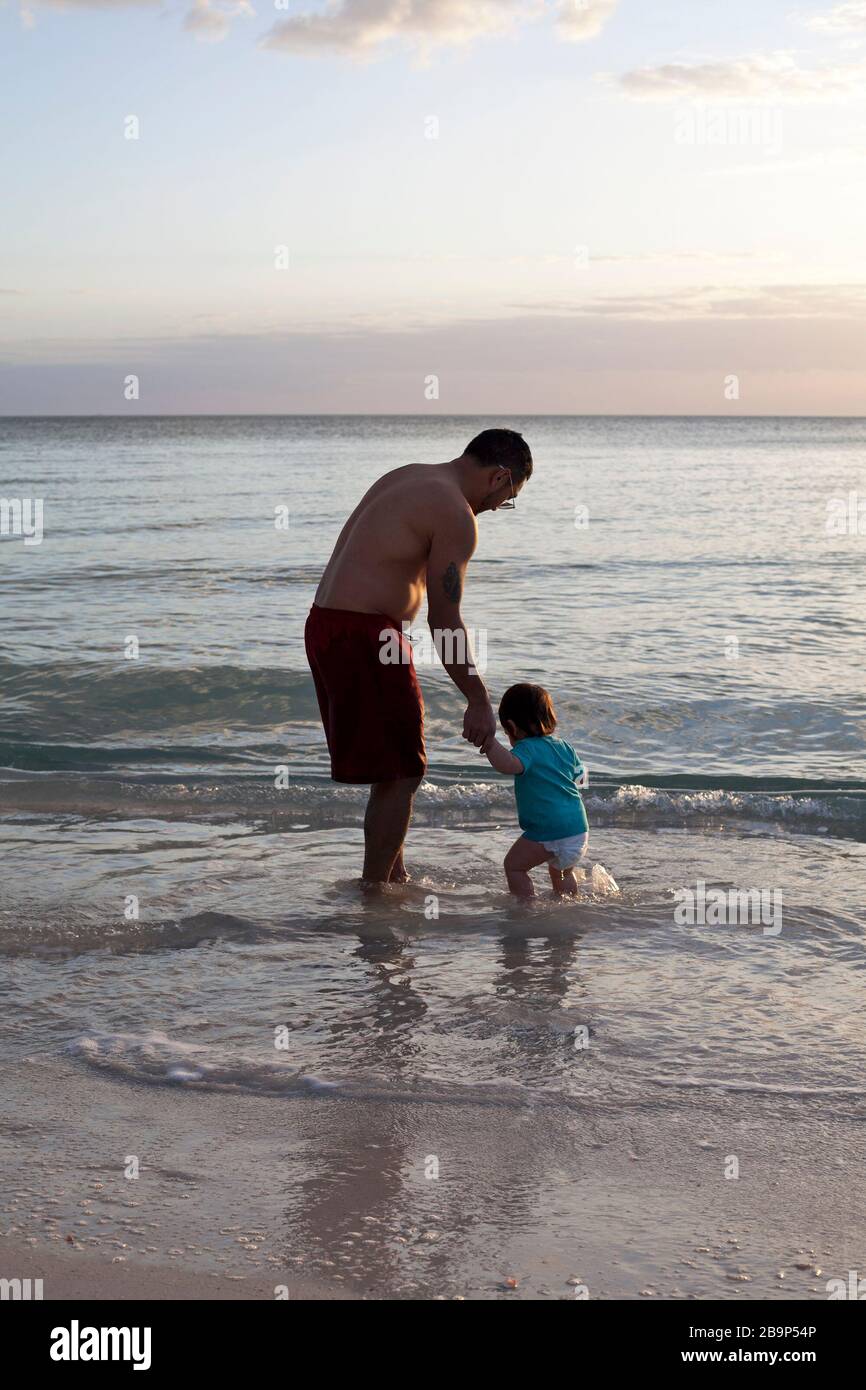 A father and son play in the ocean on Anna Maria Island in Florida, USA ...