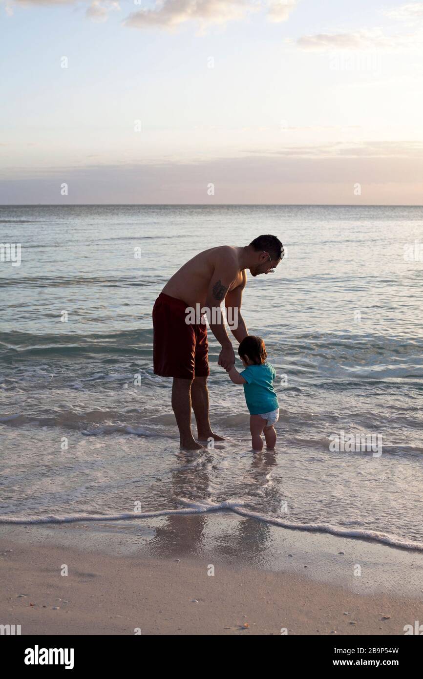 A father and son play in the ocean on Anna Maria Island in Florida, USA ...