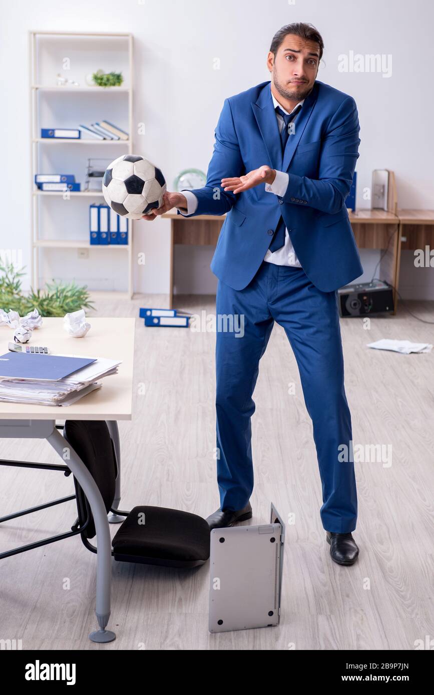 Young employee playing football in the office Stock Photo - Alamy