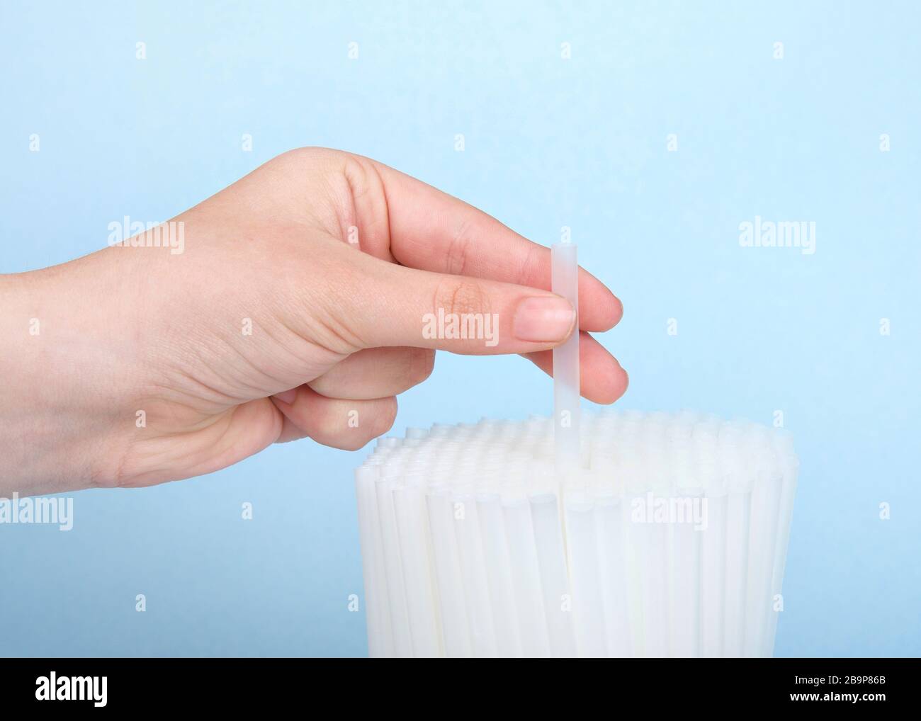 hand pulling one straw out of a bundle of compostable plant based ...