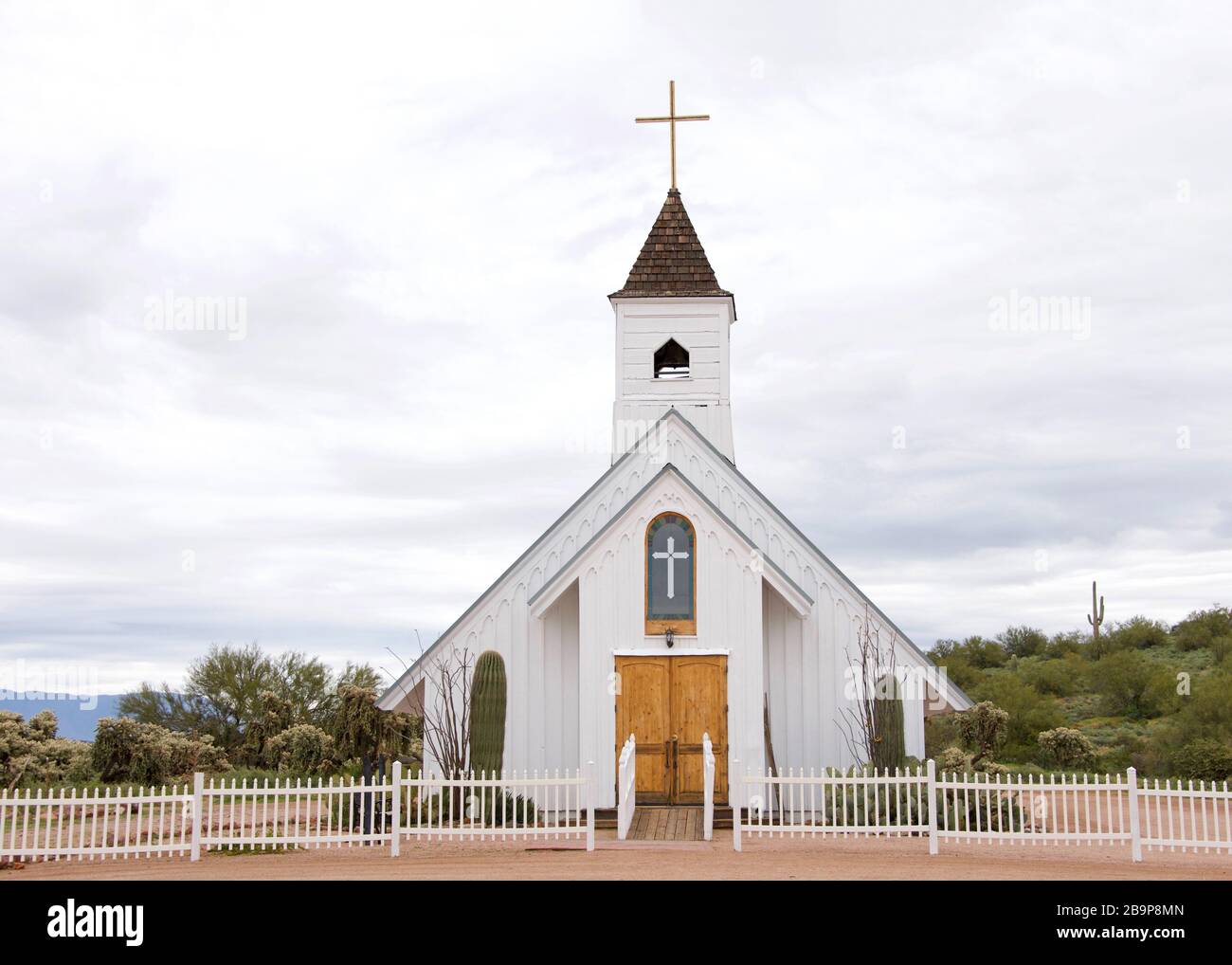 Small rustic white church in desert landscape with white picket fence ...