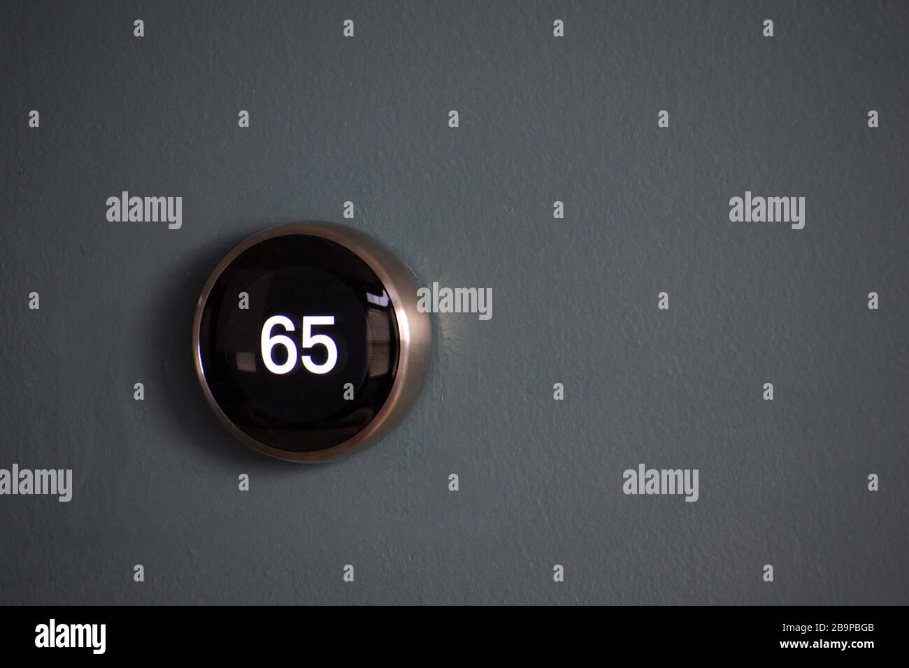 Smart home thermostat displaying temperature at an energy saving 65 ...