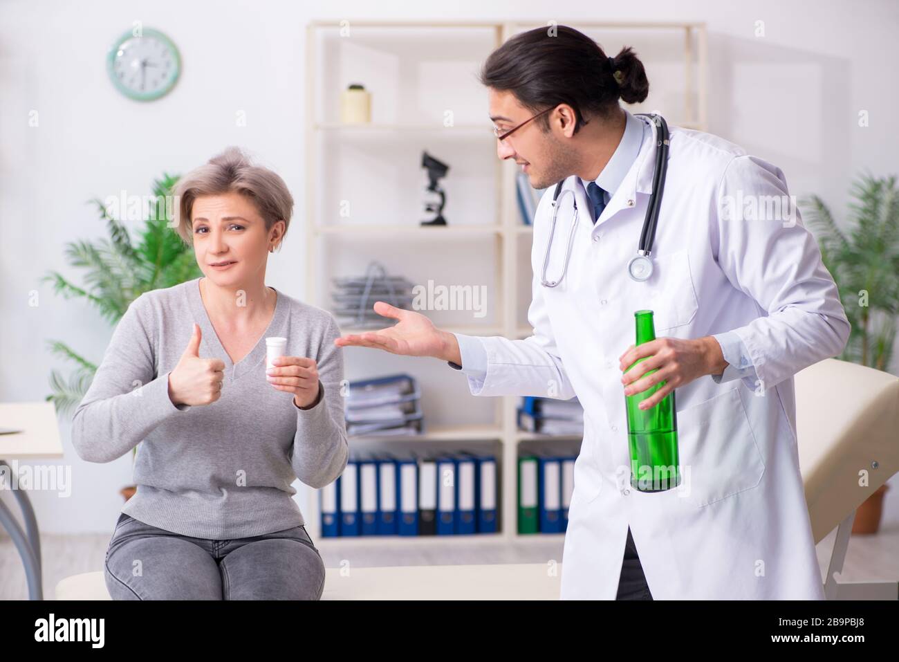 The female alcoholic visiting young male doctor Stock Photo - Alamy