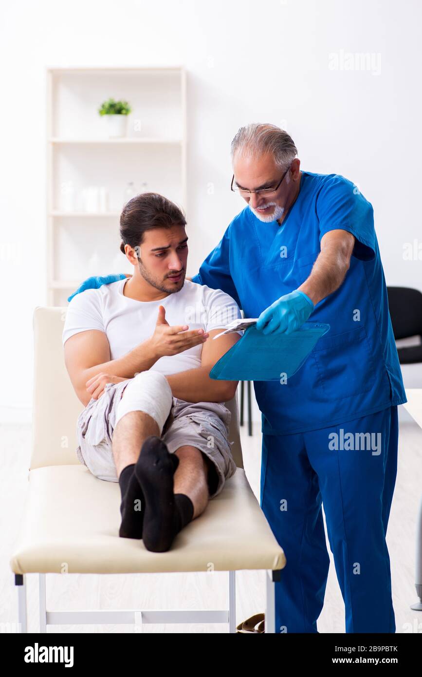 Leg injured man visiting doctor in first aid concept Stock Photo - Alamy