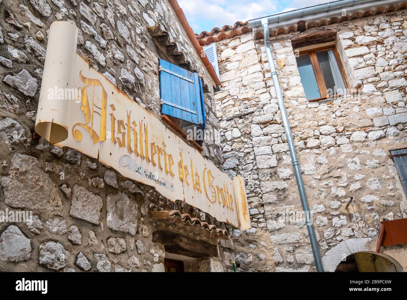 A picturesque shop sign under a colorful French Blue shutter in the ...