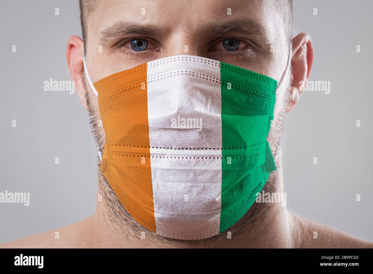 Young man with sore eyes in a medical mask painted in the colors of the ...