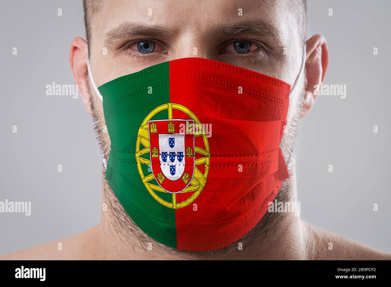 Young man with sore eyes in a medical mask painted in the colors of the ...