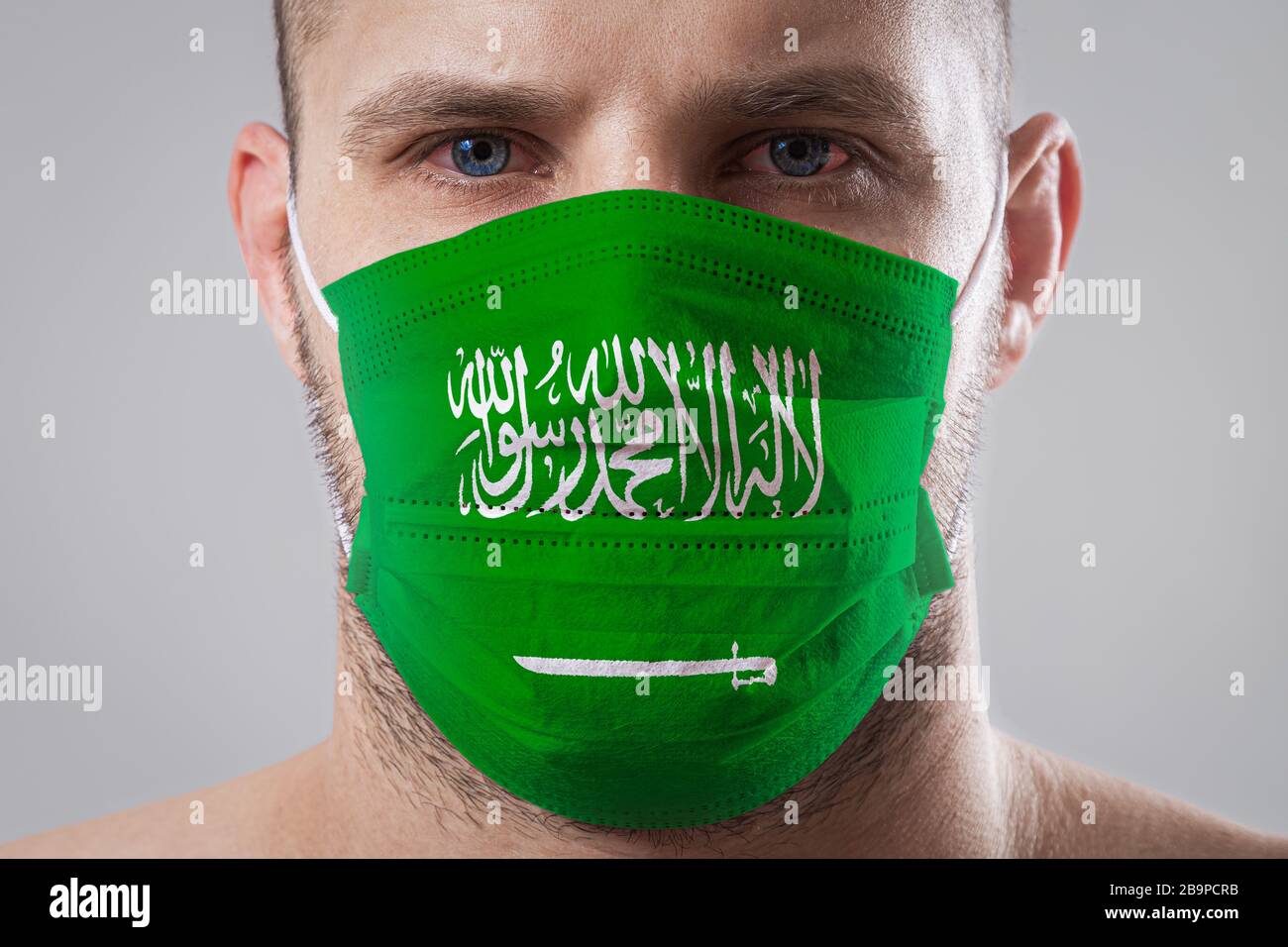Young man with sore eyes in a medical mask painted in the colors of the ...