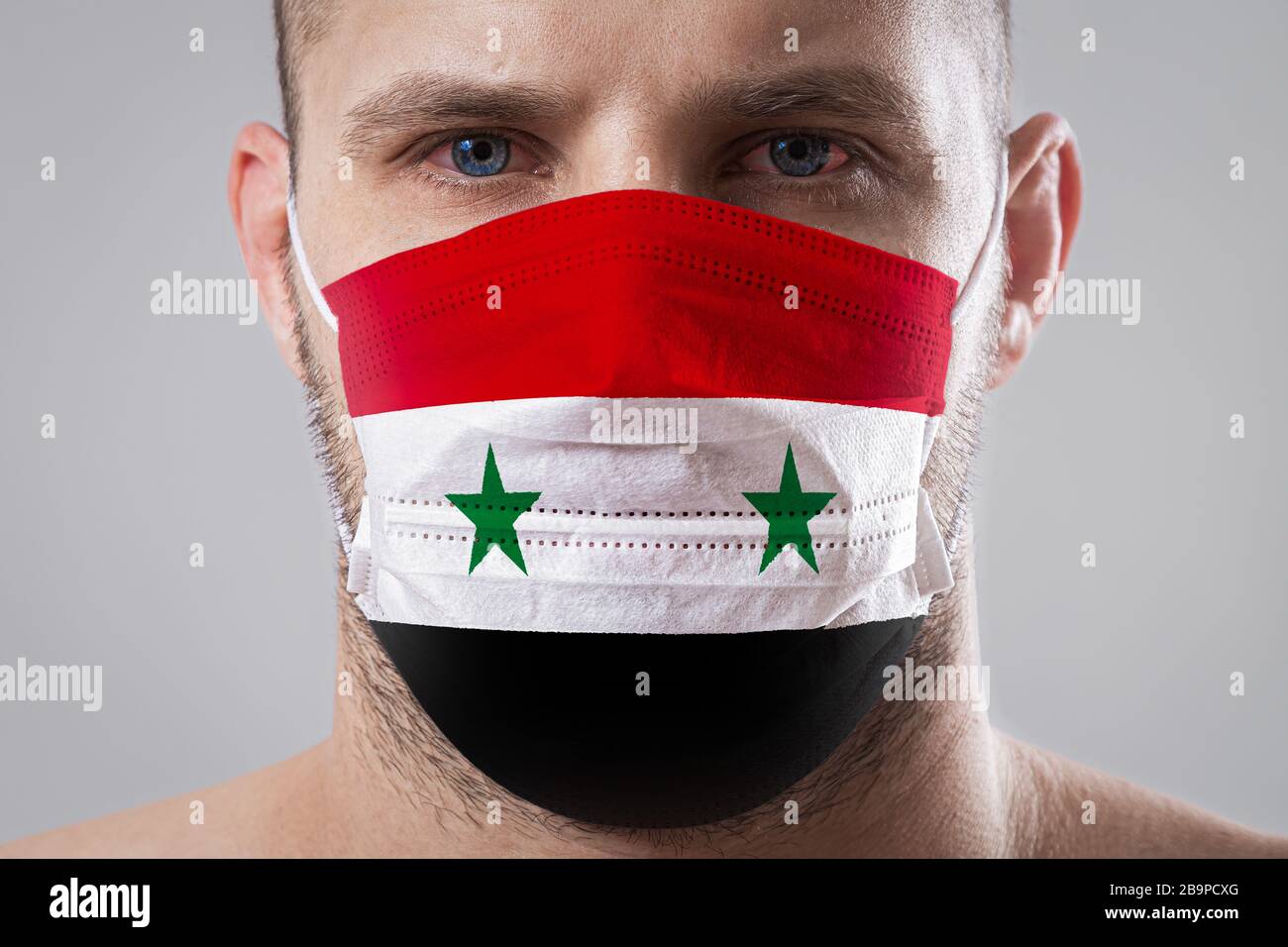 Young man with sore eyes in a medical mask painted in the colors of the ...