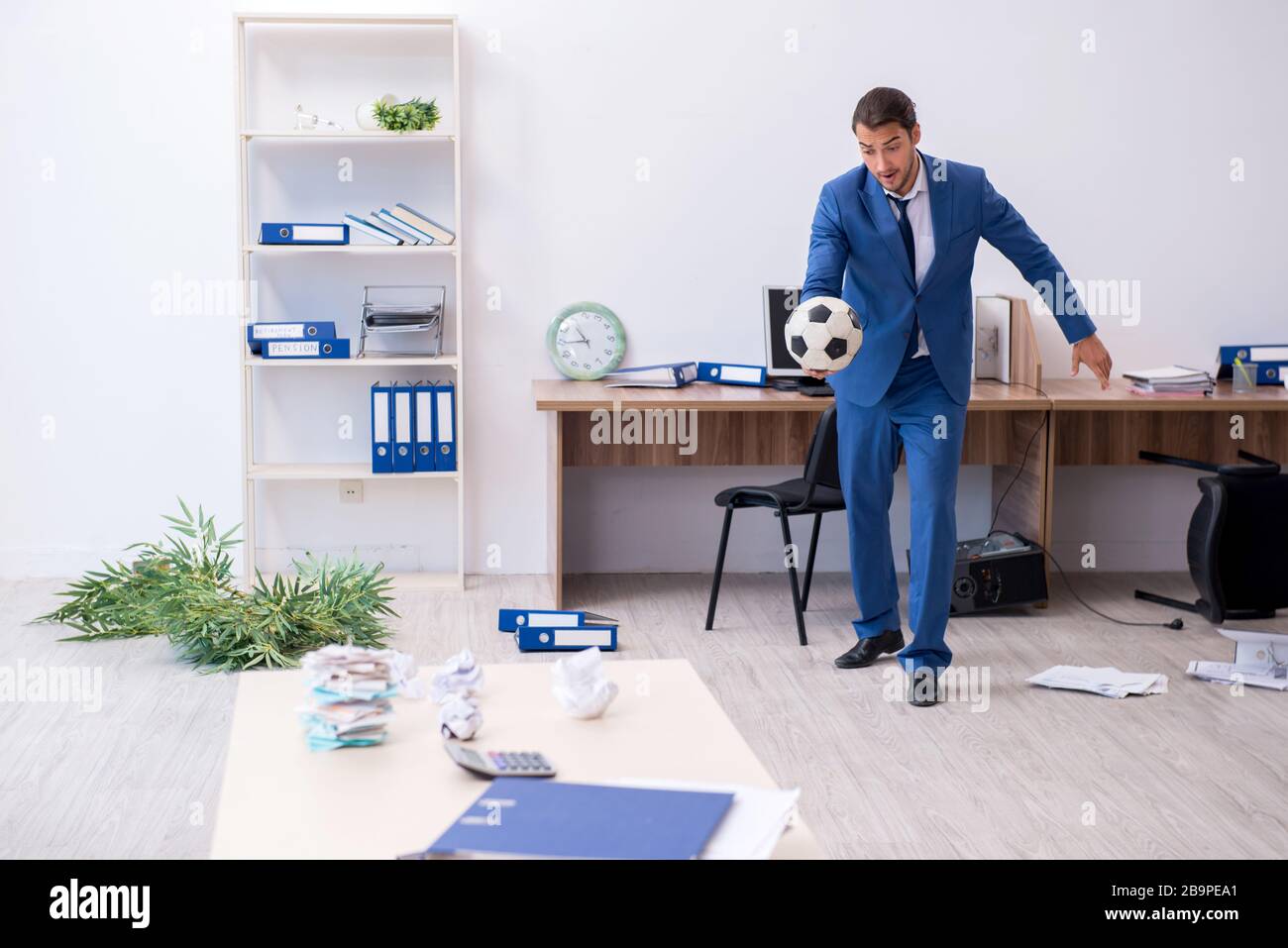 Young employee playing football in the office Stock Photo - Alamy