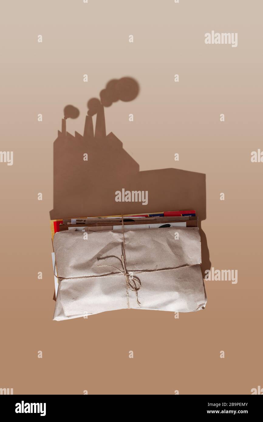 A stack of waste paper casts a hard shadow in the form of a garbage ...