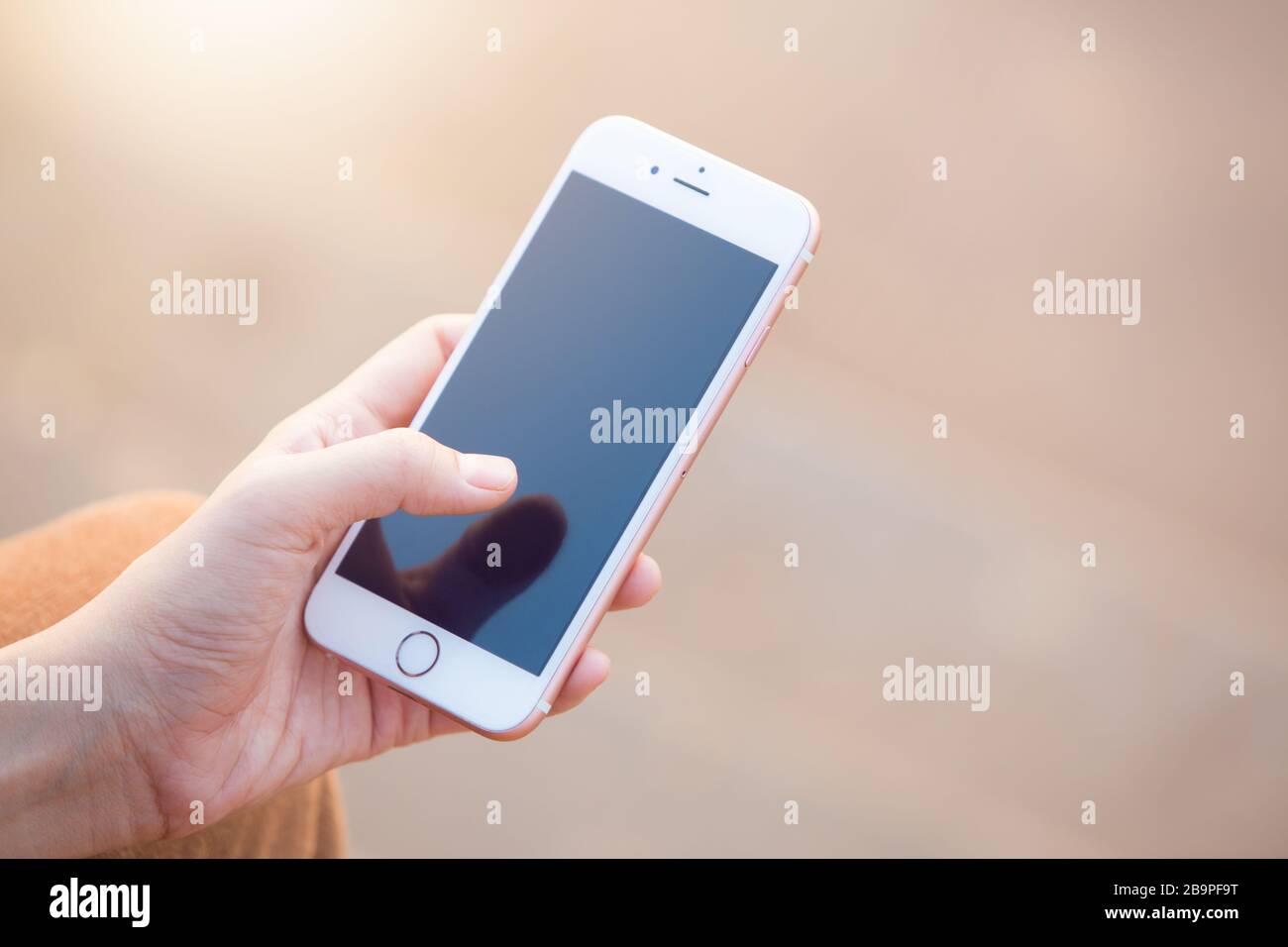 Beautiful young woman's hand using smart phone at beach,flare light ...